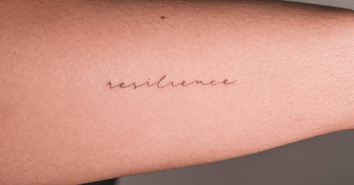 Tattoo of the word "resilience" handwritten on the