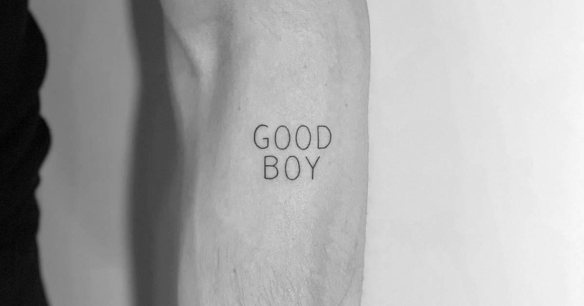 "Good boy" lettering tattoo placed on the forearm.