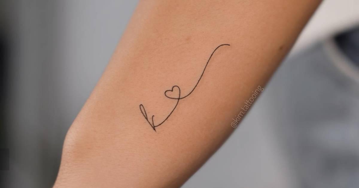 Minimalistic letter "K" and heart tattoo located on the