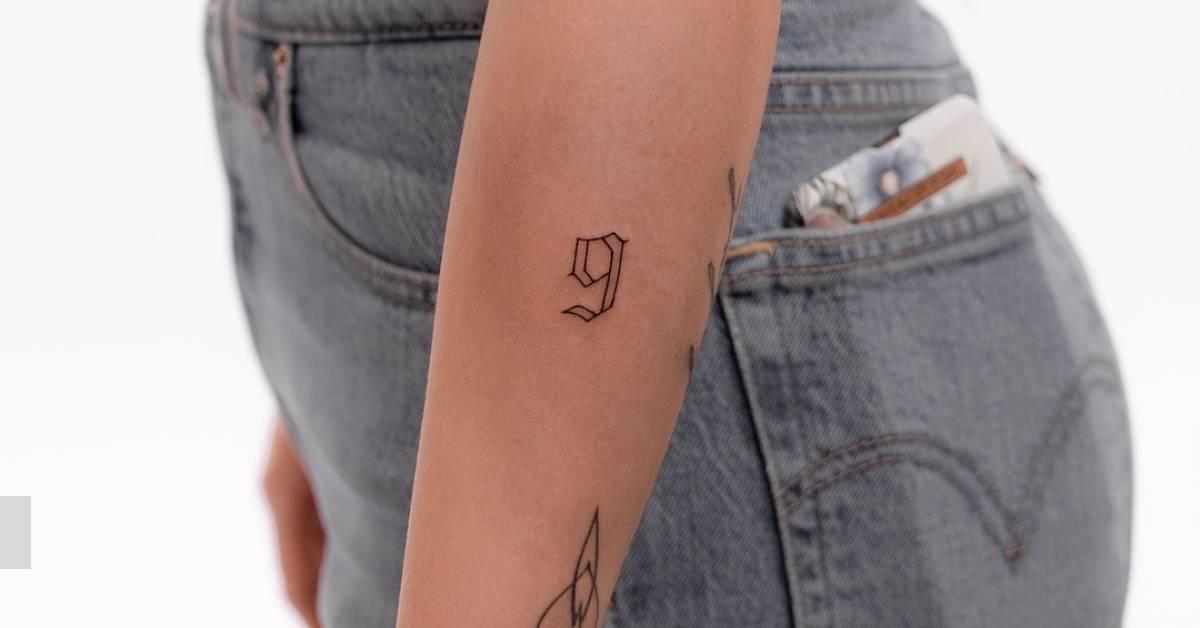Tattoo of the number "9" located on the forearm.