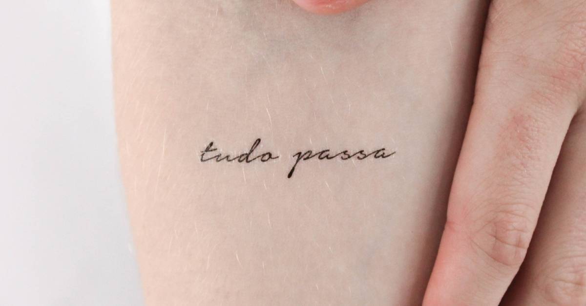 "Tudo passa" temporary lettering tattoo located on the