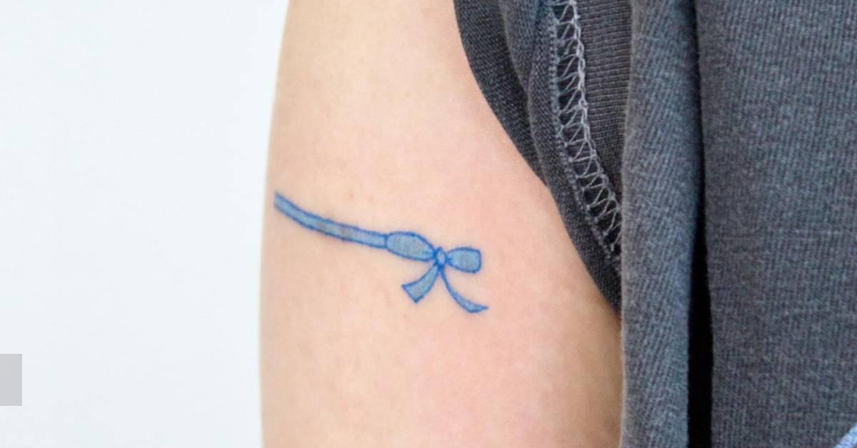 Ribbon tattoo in watercolor style located on the upper
