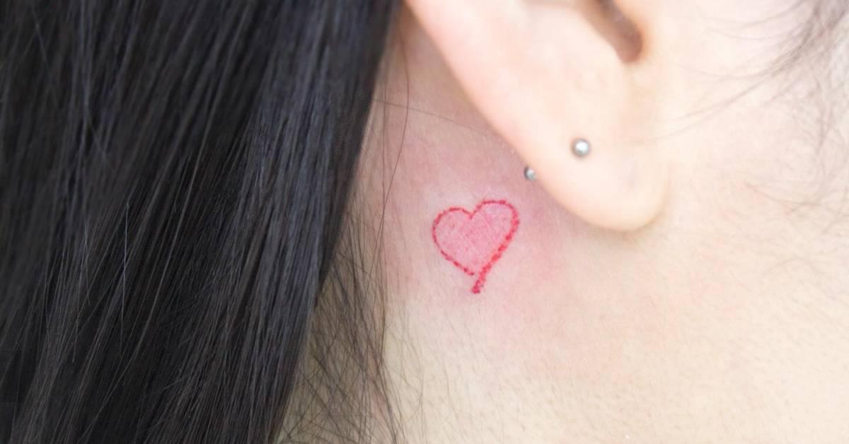 Cute little heart tattoo located behind the ear.