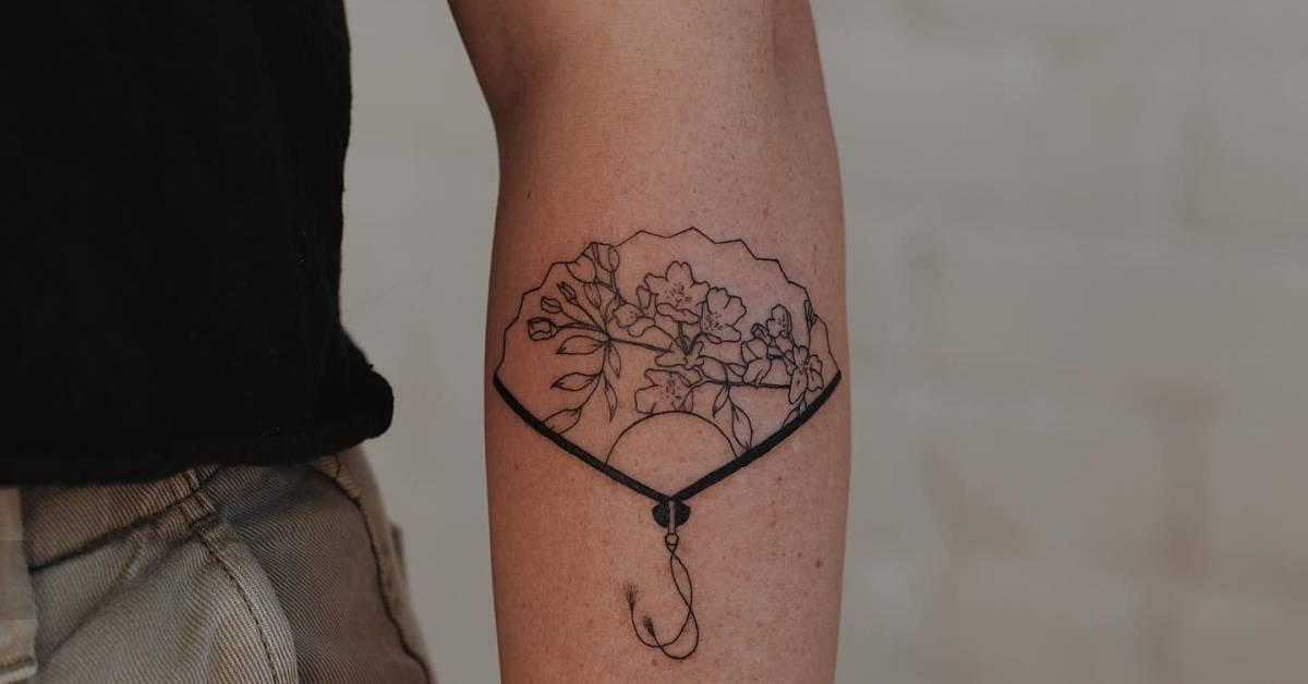 Fine line style hand fan tattoo located on the forearm.
