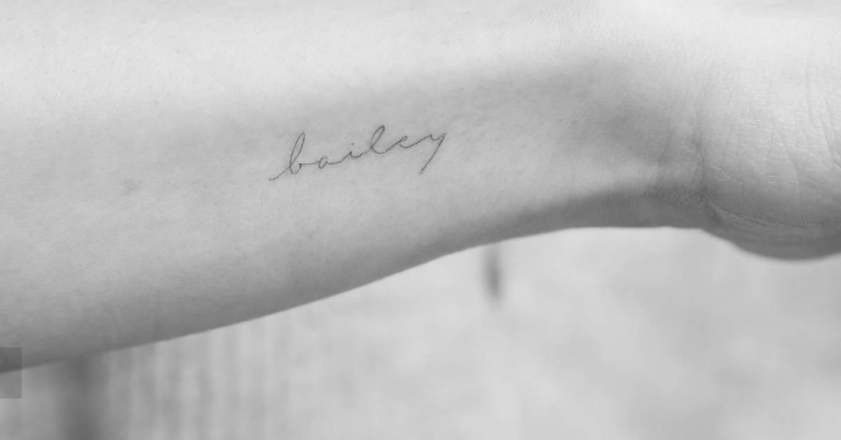 "Bailey" lettering tattoo handwritten on the wrist.