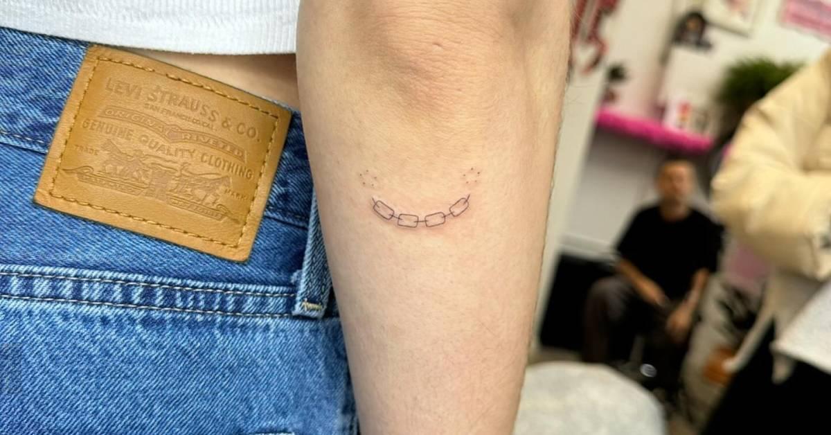 Minimalistic style chain tattoo located on the forearm.