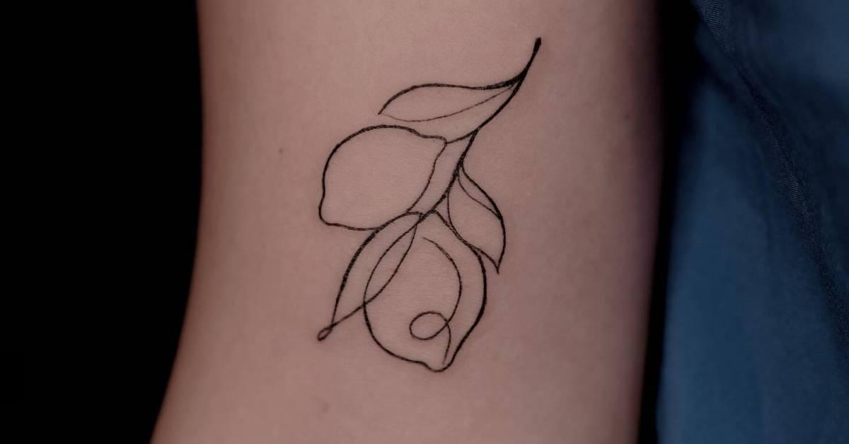 Fine line style lemon tattoo located on the bicep.
