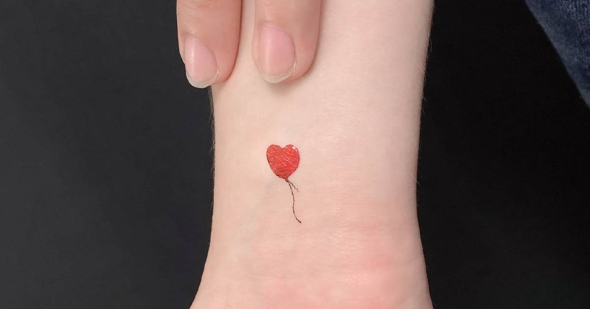 Red balloon temporary tattoo located on the wrist.