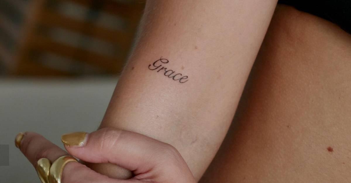 "Grace" lettering tattoo located on the upper arm.