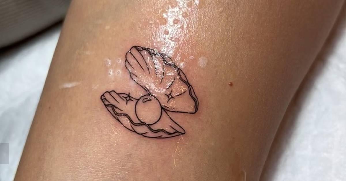 Fine line style scallop shell tattoo done on the bicep.