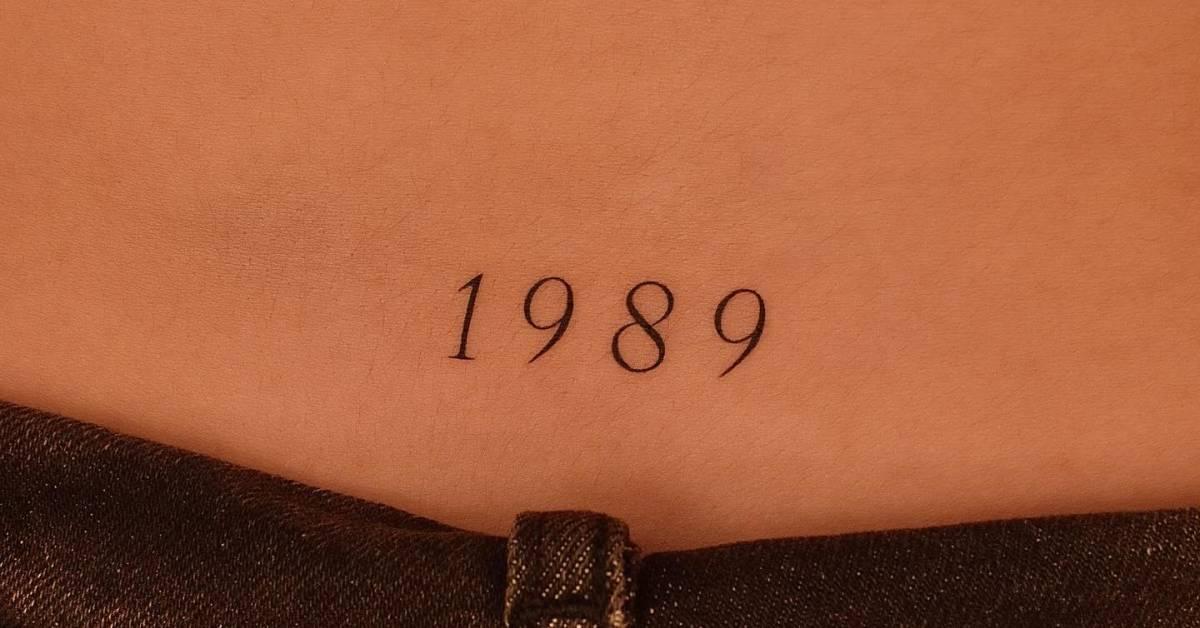 "1989" lettering tattoo placed on the lower back.