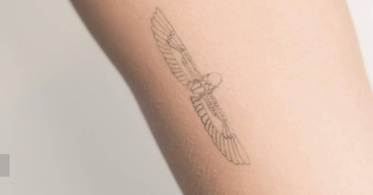 Healed fine line scarab tattoo done on the inner arm.