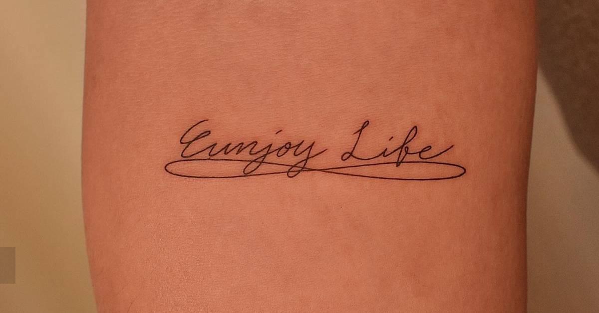 "Enjoy life" lettering tattoo handwritten on the inner