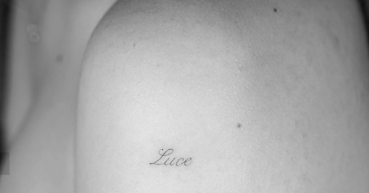 Tattoo of the word "luce" handwritten on the shoulder.