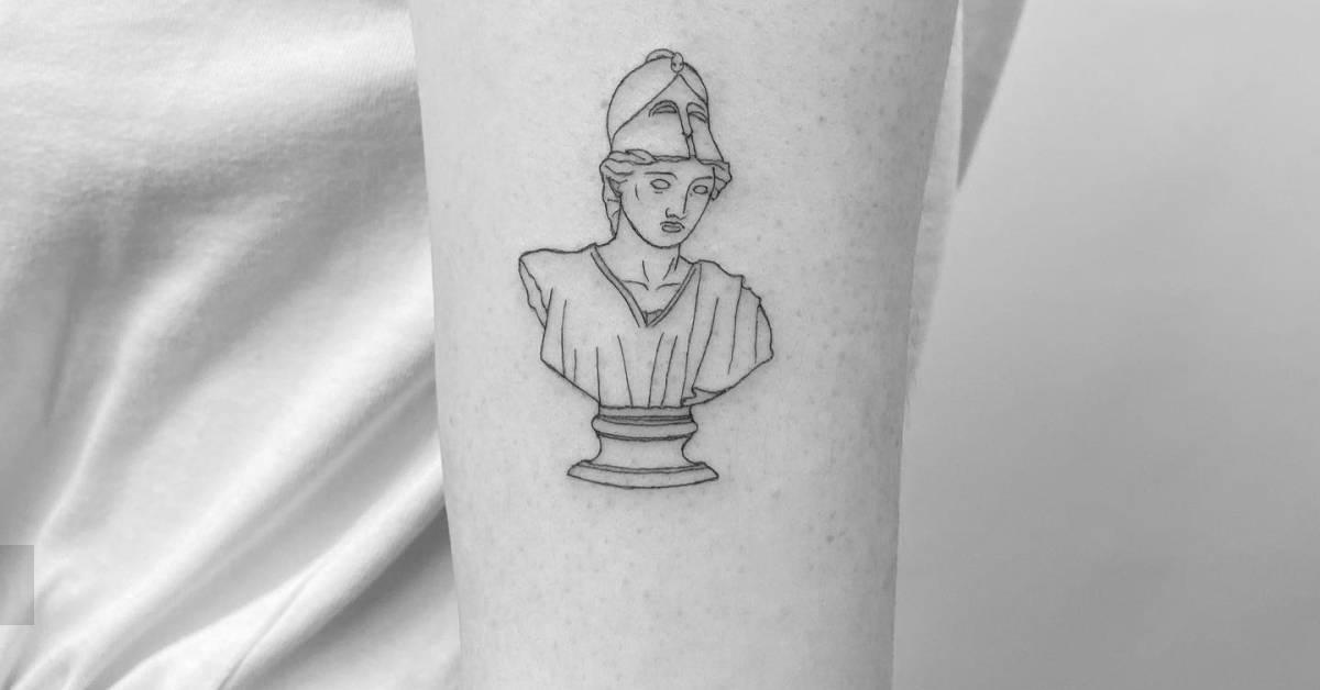 Fine line style Athena tattoo located on the upper arm.