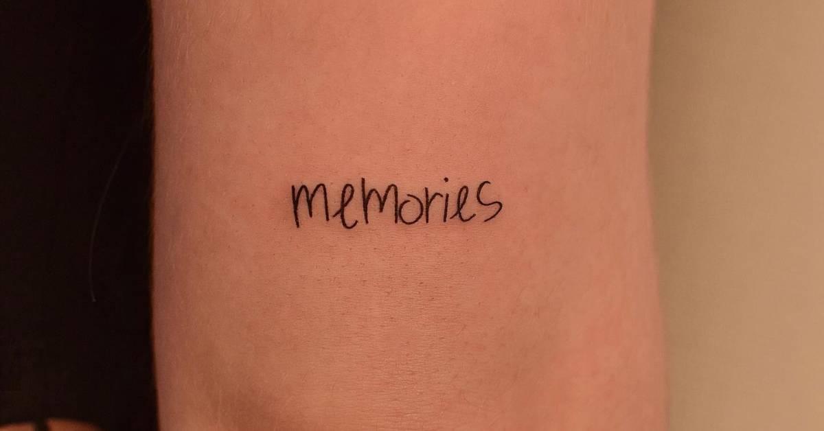 "Memories" lettering tattoo handwritten on the tricep.
