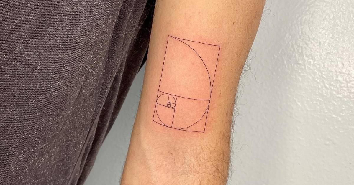 Fine line style golden spiral tattoo placed on the