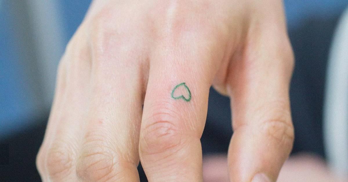 Minimalistic style green heart tattoo done on the