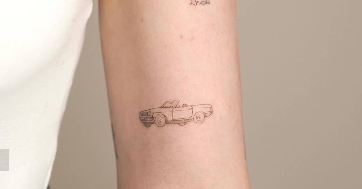 Fine line style car tattoo located on the bicep.