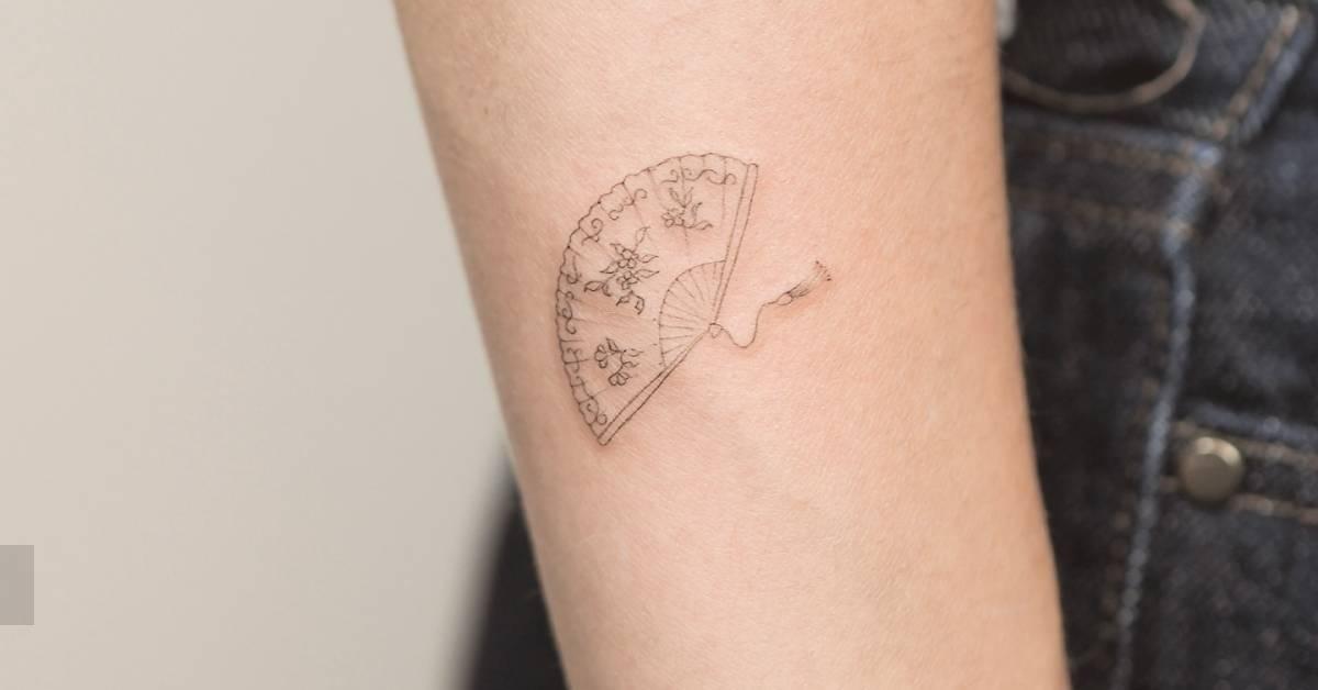 Fine line style hand fan tattoo located on the forearm.