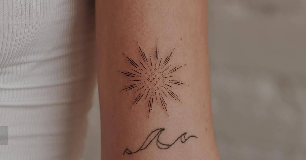 Fine line style ornamental sun tattooed on the bicep.