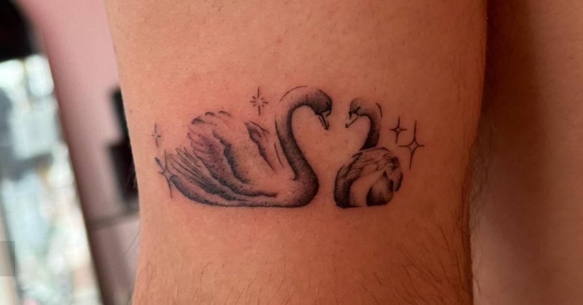Swans tattooed on the tricep, done in illustrative
