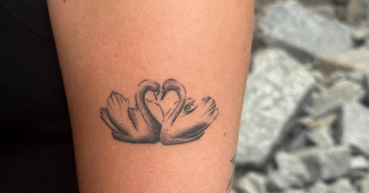 Healed swans tattooed on the upper arm, illustrative