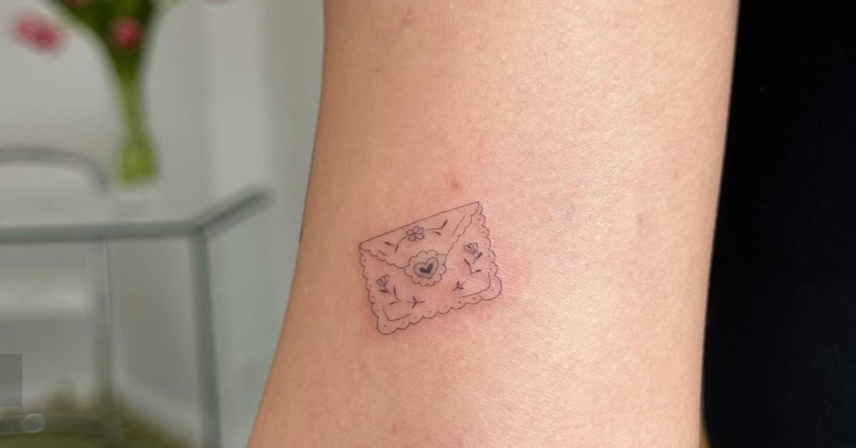Fine line style love letter tattoo located on the
