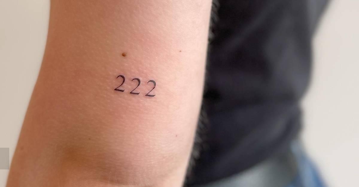 Tattoo of the angel number "222" placed on the tricep.
