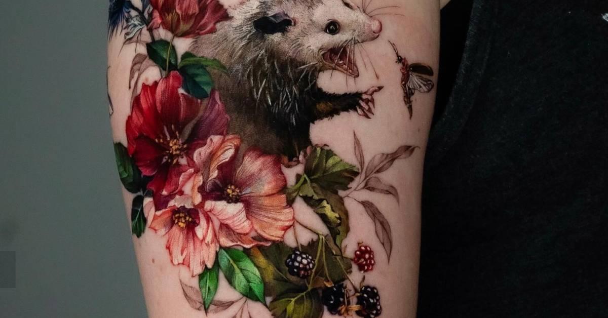 Opossum And Flowers Tattoo Located On The Upper Arm