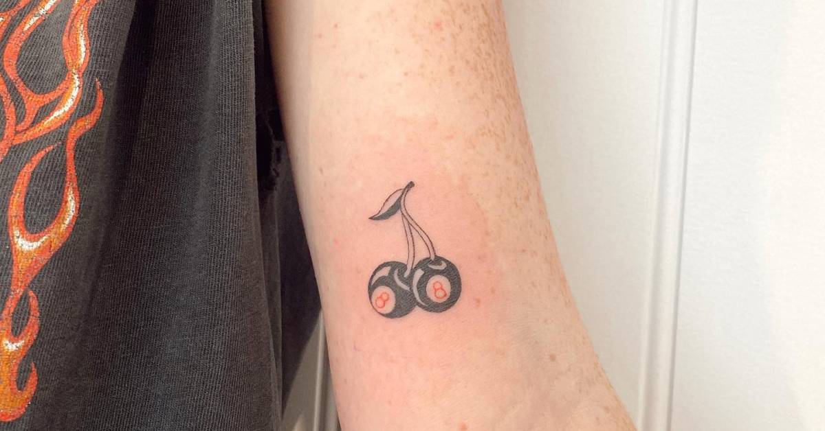 Cherry eight ball tattoo located on the inner arm.