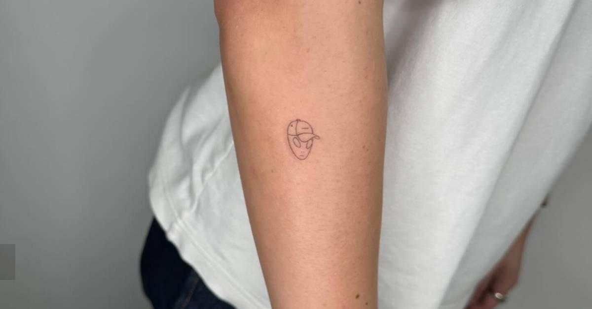 Fine line style alien head tattoo located on the