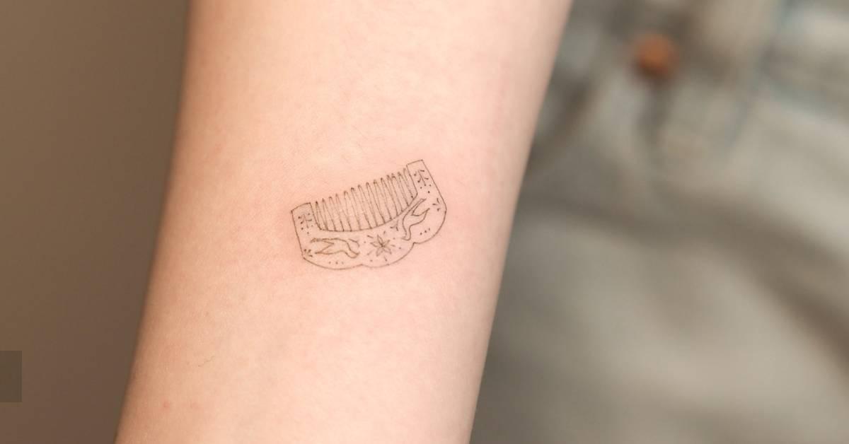 Fine line style comb tattoo located on the inner