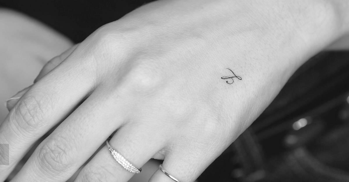 Tiny letter "L" tattoo located on the hand.