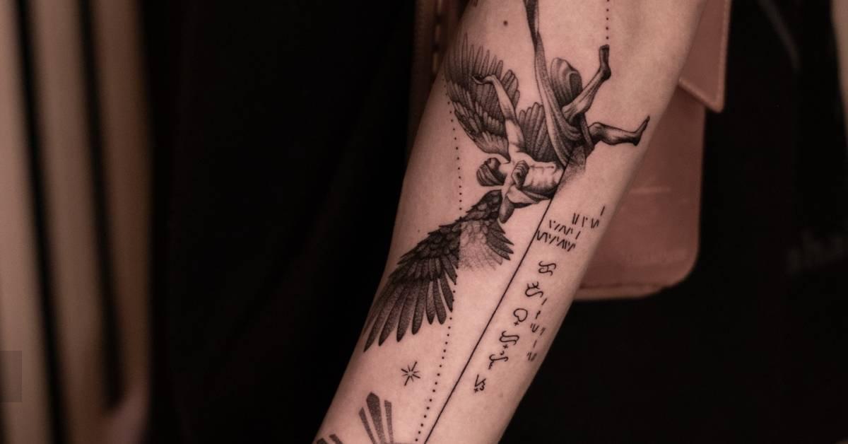 Graphic style angel tattoo located on the forearm.