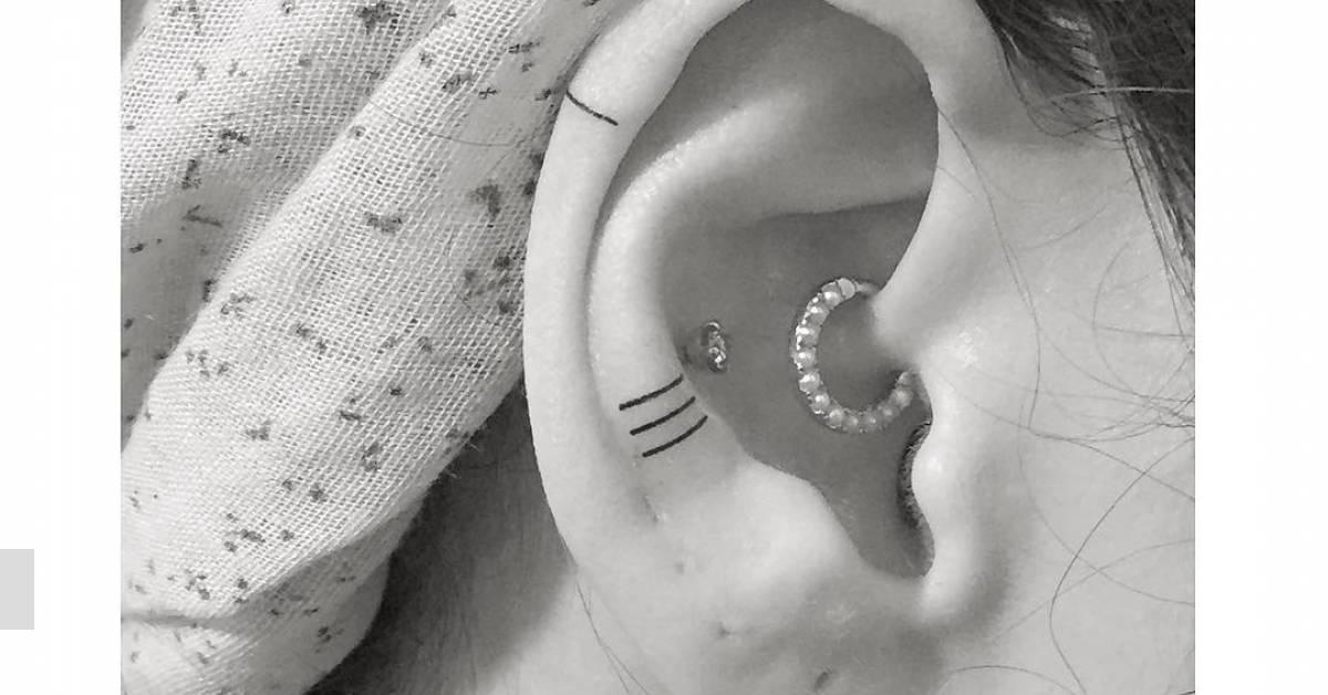 Minimalistic style lines tattooed on the ear.