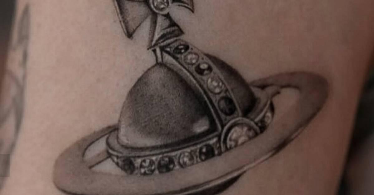 Vivienne Westwood orb tattooed on the upper arm.