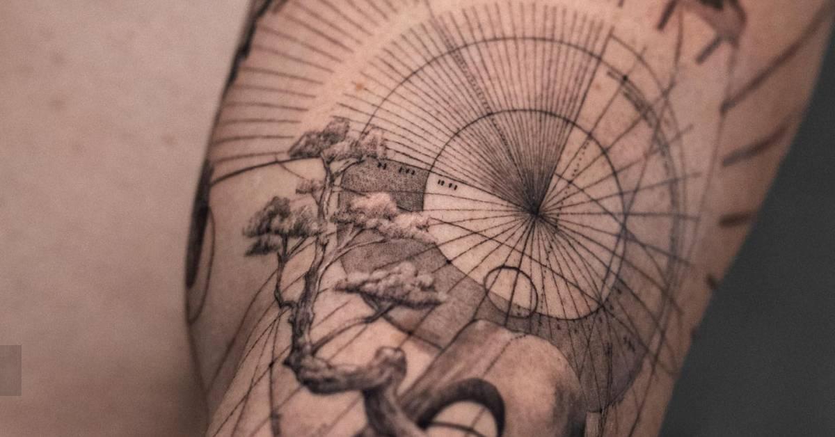 Graphic style upper arm composition tattoo.