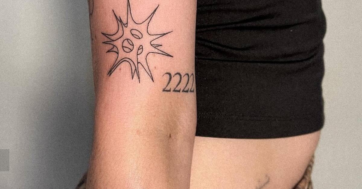 Spikes tattoo located on the upper arm, line art style.