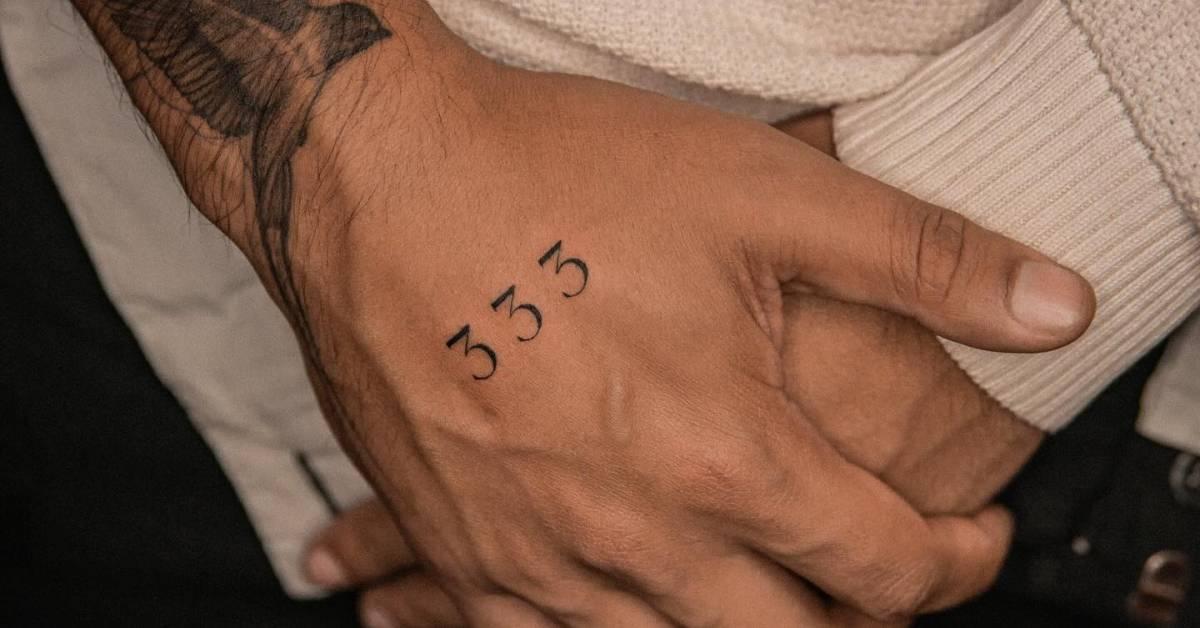 Angel number "333" tattoo located on the hand.
