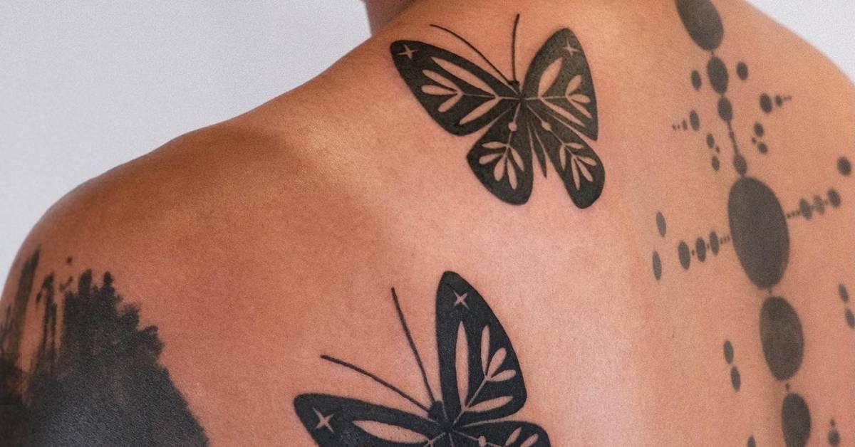 Blackwork style butterflies tattoo located on the