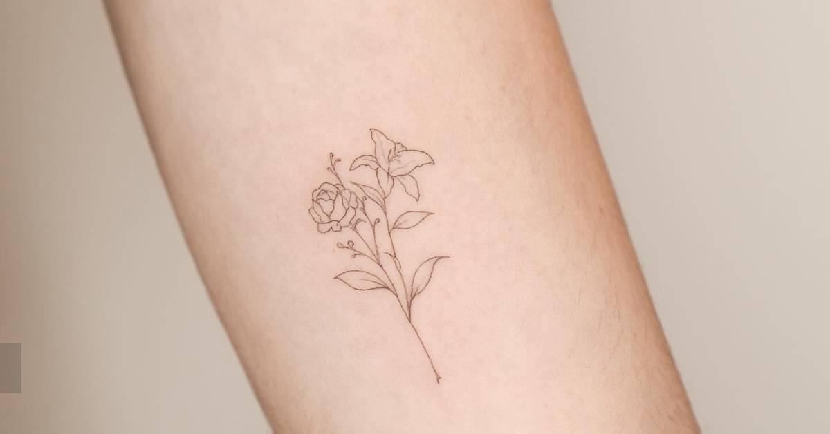 Fine line style rose and lily tattoo located on the