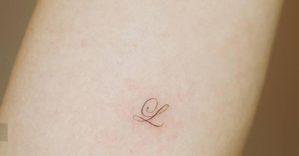 Little letter "L" tattoo located on the inner arm.