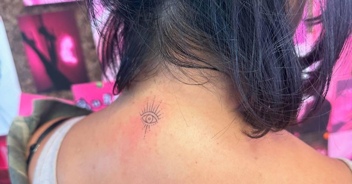Fine line style evil eye tattoo located on the upper