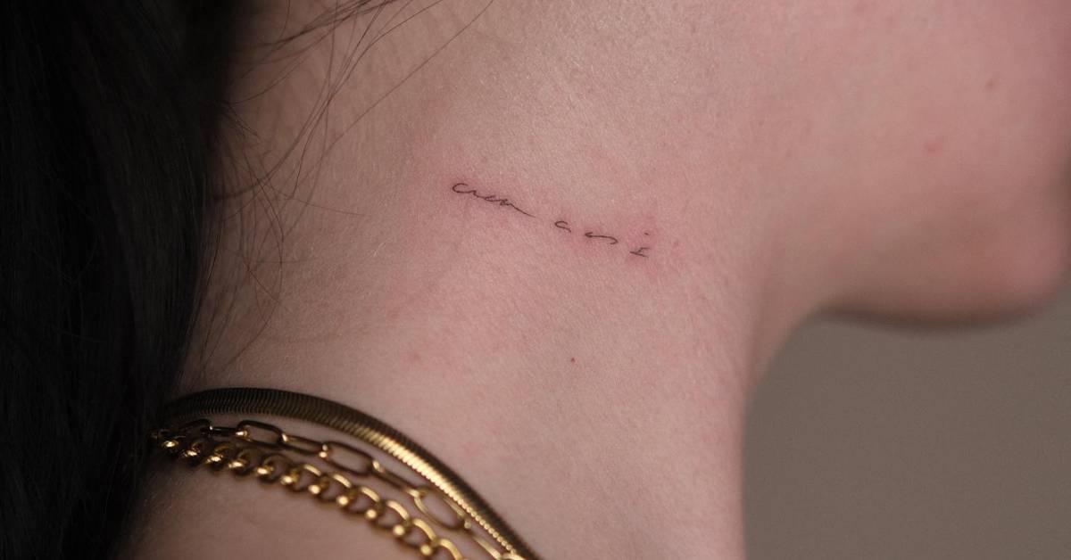 Handwritten lettering tattoo located on the neck.