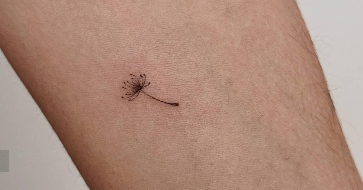 Minimalistic dandelion seed tattoo located on the inner