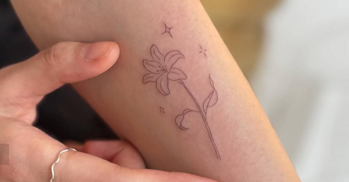 Lily flower tattoo in fine line style placed on the