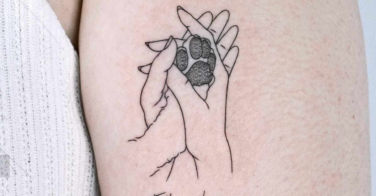 Hand and paw tattoo located on the upper arm.