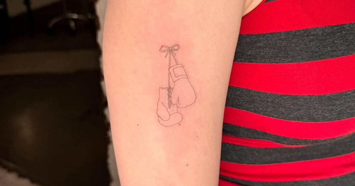 Fine line style boxing gloves tattoo located on the