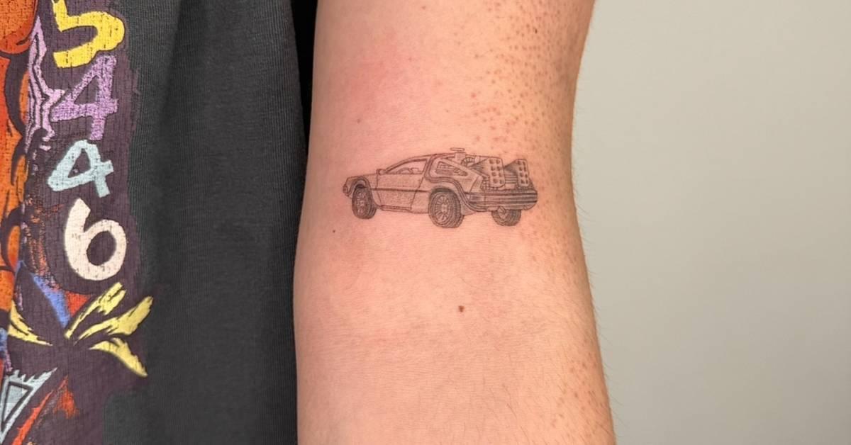 Single needle DeLorean tattoo located on the bicep.